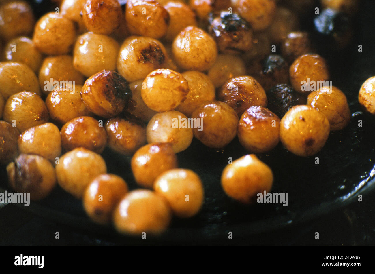 Small whole onions cooking in a restaurant kitchen Stock Photo - Alamy