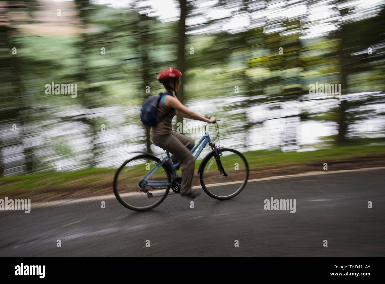 Woman enjoying a fast bike ride, Lake Vyrnwy Stock Photo - Alamy
