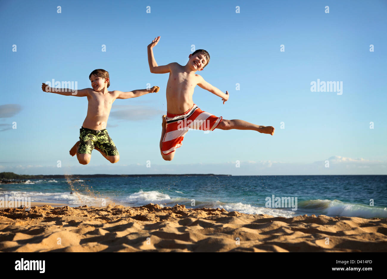 two boys jumping at the beach Stock Photo - Alamy