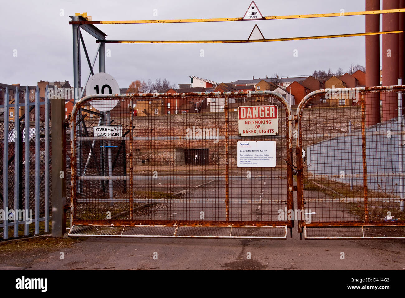 Danger and inflammable warning signs on gates showing overhead gas ...