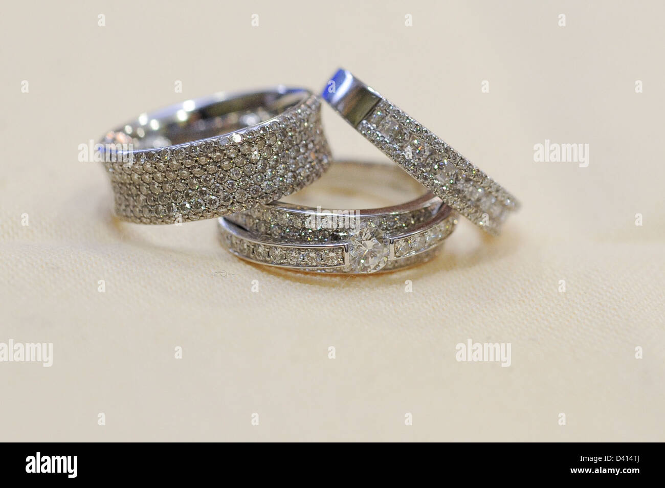 Three white gold diamond rings on a cream background Stock Photo - Alamy