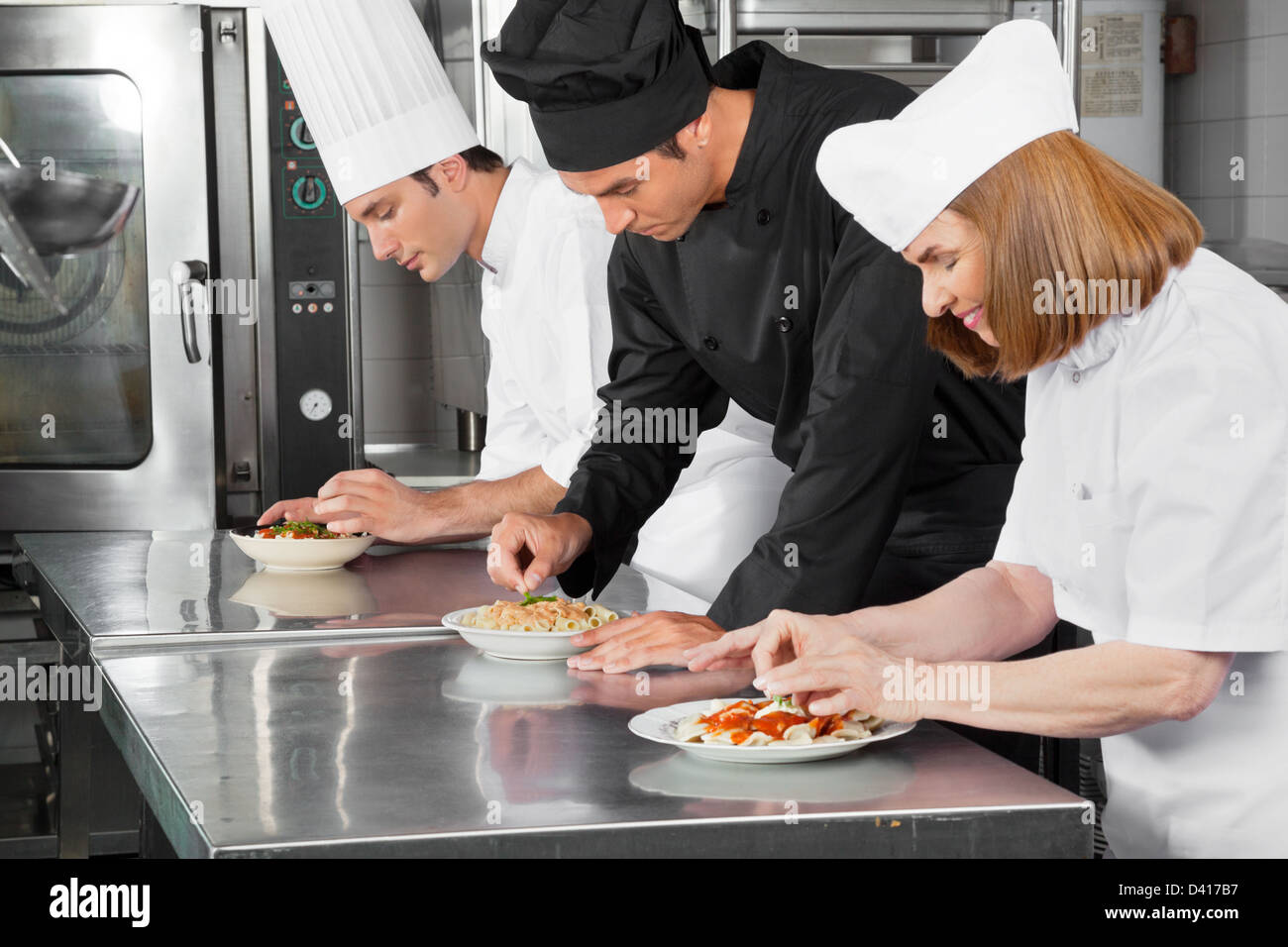 Chefs Garnishing Dishes On Counter Stock Photo - Alamy