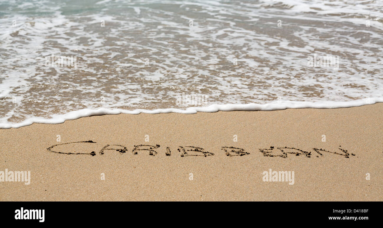 Caribbean words written into sand on beach by sea in St Thomas Stock ...