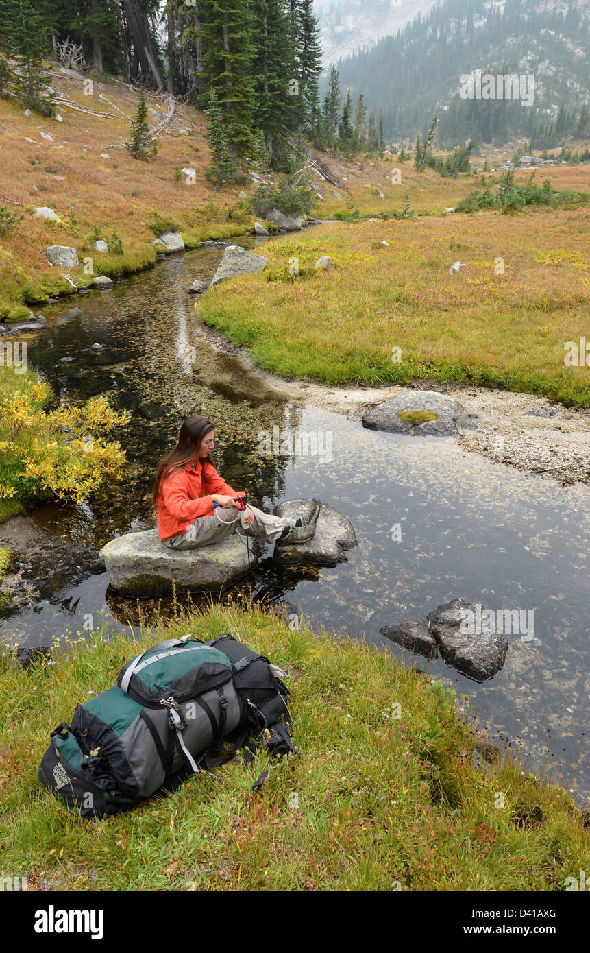 Hiker using a water filter in Oregon's Wallowa Mountains Stock Photo ...