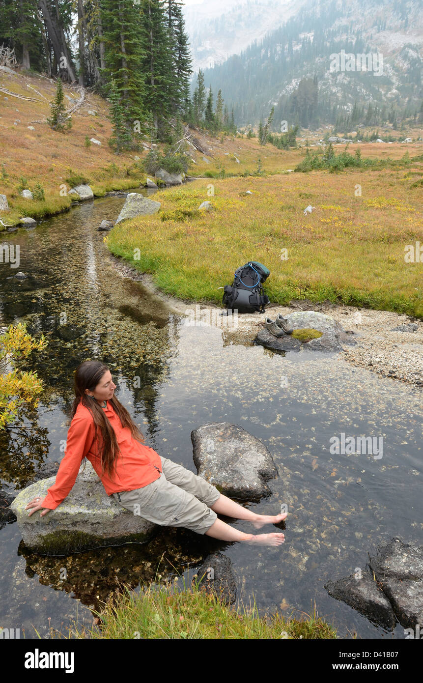 Hiker soaking feet in a stream high on a backpack trip in Oregon's ...