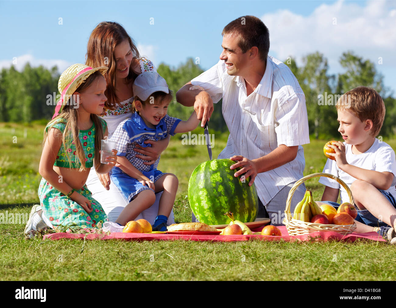 outdoor group portrait of happy family having picnic on green grass in ...