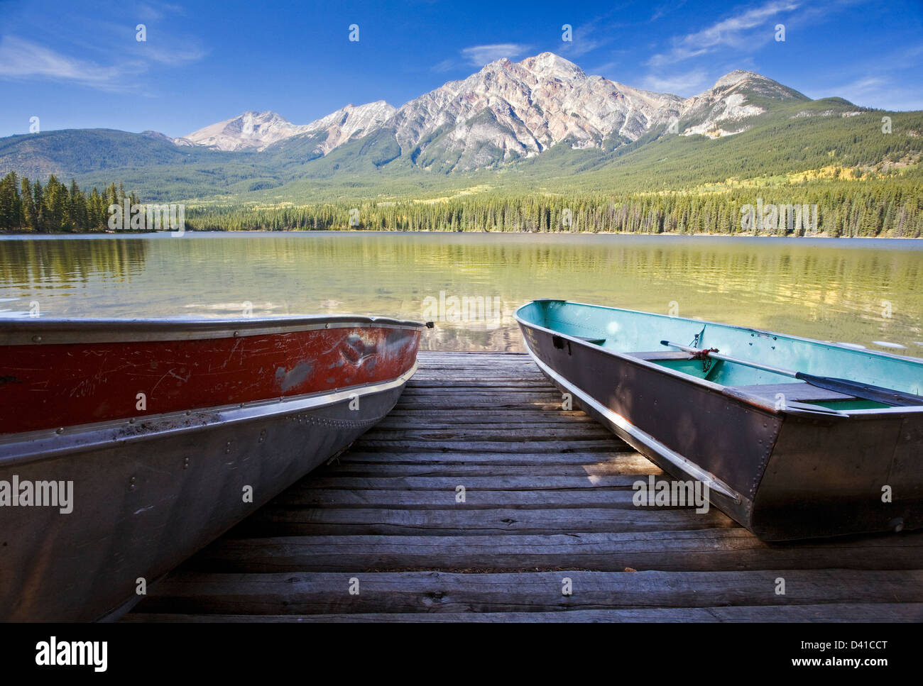 Row boats on dock with Pyramid Mountain Stock Photo - Alamy