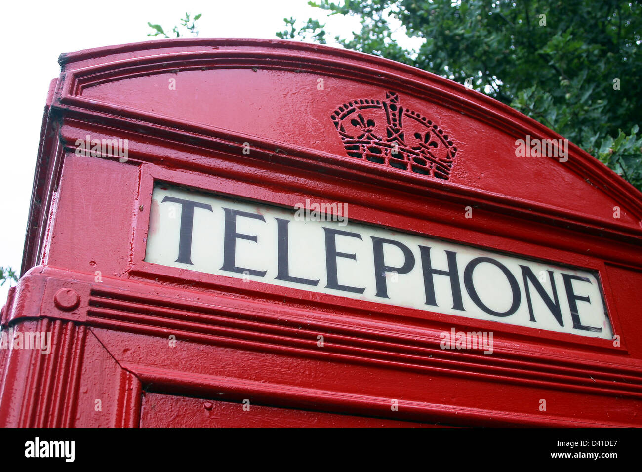 Detail of red telephone box showing domed roof, sign and royal crown ...