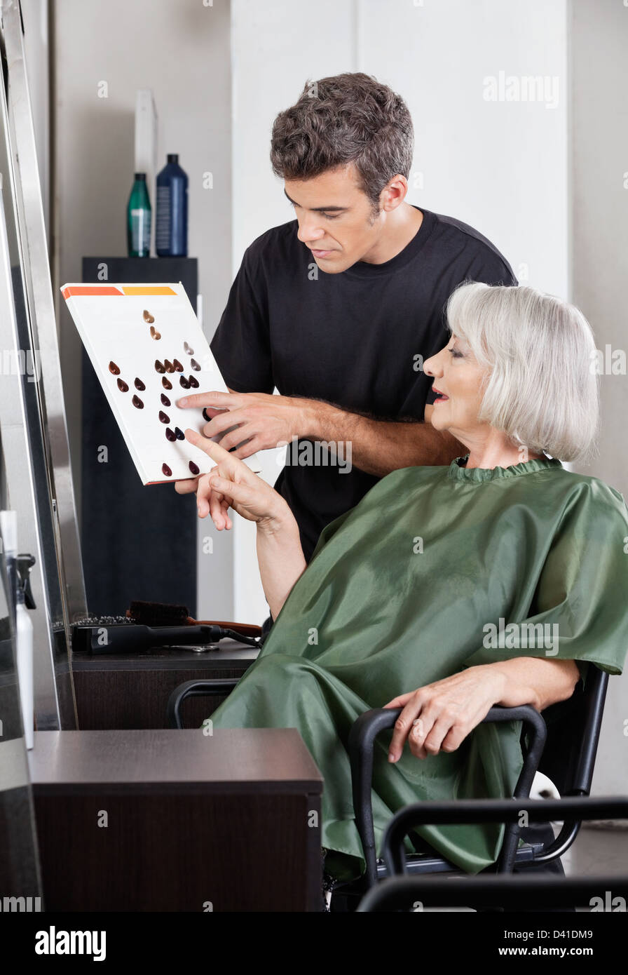 Hairdresser Advising Female Client In Selecting Color Stock Photo - Alamy