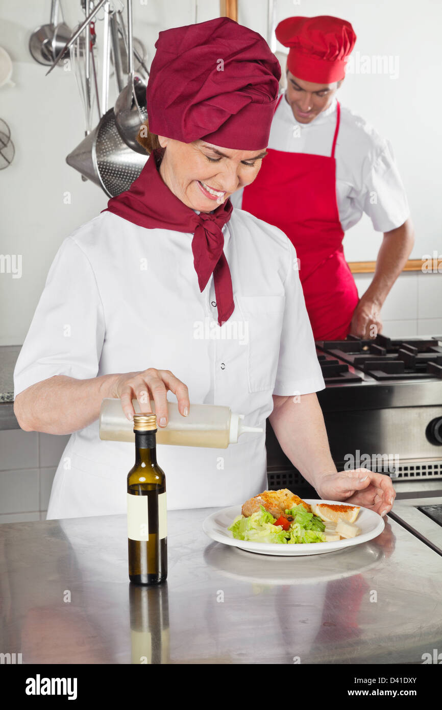 Young woman pouring oil on hi-res stock photography and images - Alamy