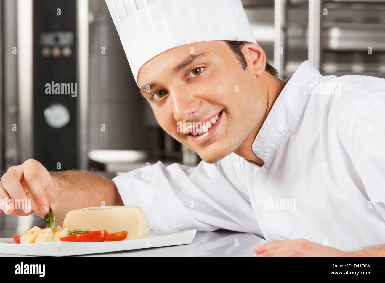 Happy Male Chef Garnishing Dish Stock Photo - Alamy