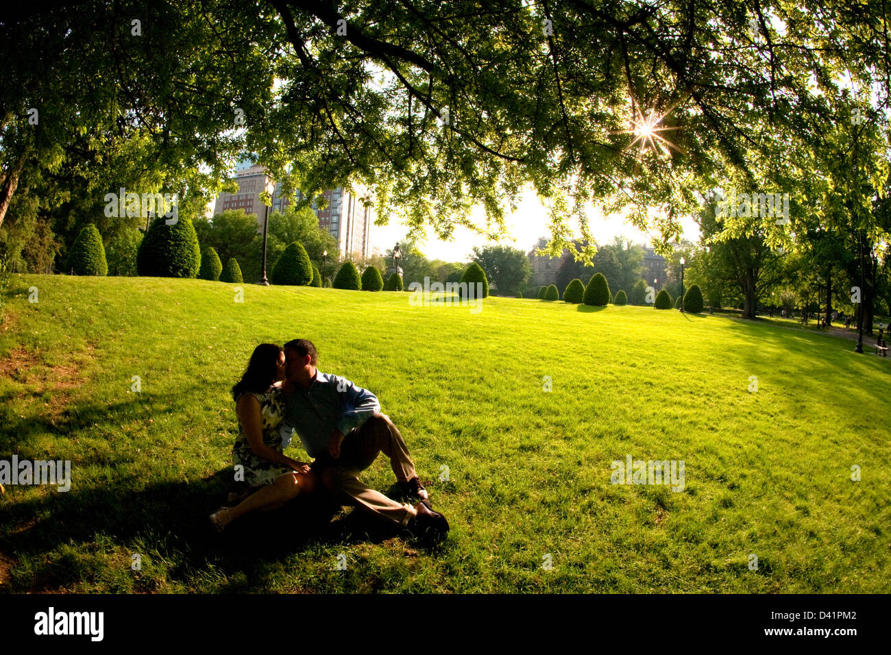 couple sitting in shadow on grassy lawn Stock Photo - Alamy