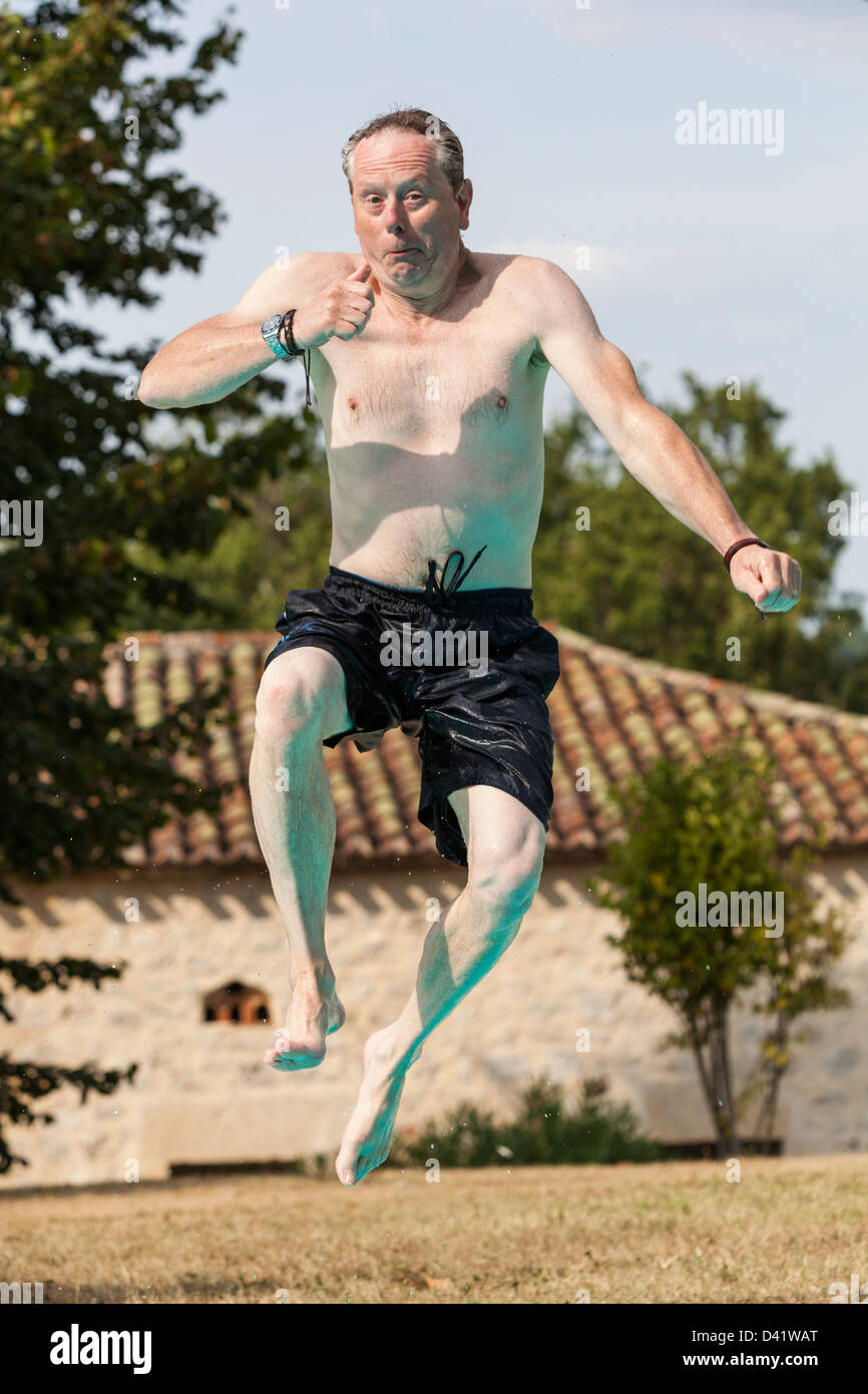 Man with a strained expression as he is jumps into the air before ...