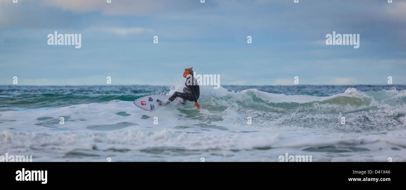 Young surfer carving a turn in the surf on Porthmeor Beach, St Ives ...