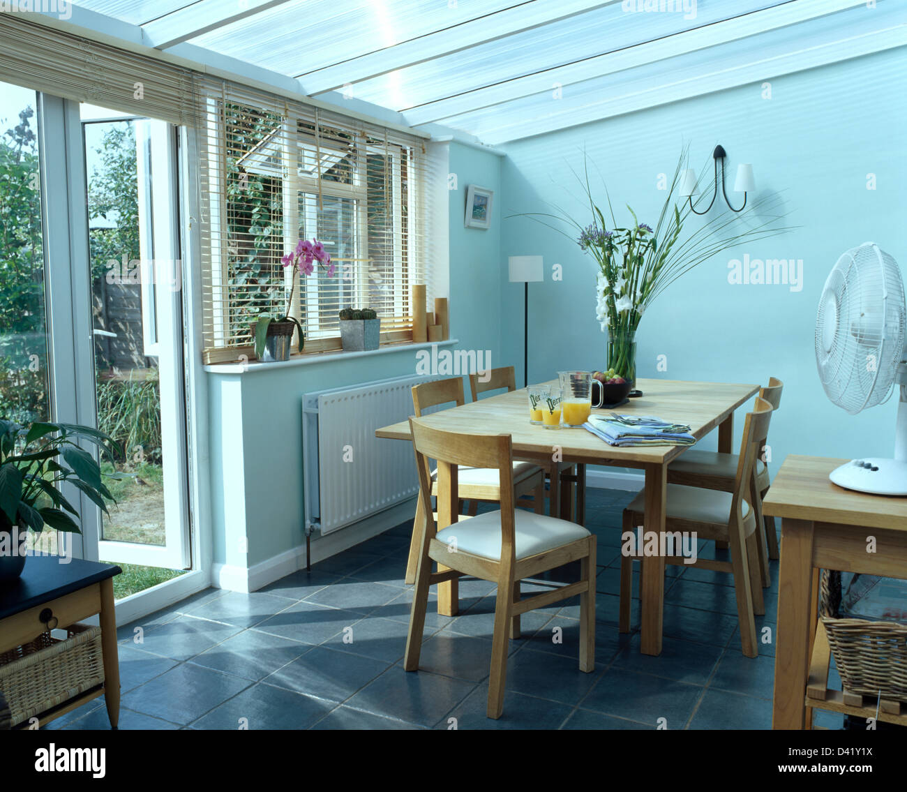 Simple wood table and chairs in economy-style dining room extension ...