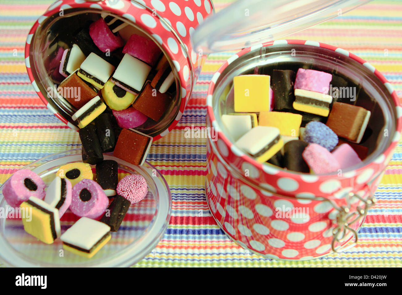 Liquorice sweets in colourful containers against a colourful background ...