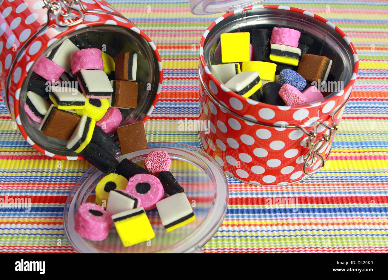 Liquorice sweets in colourful containers against a colourful background ...