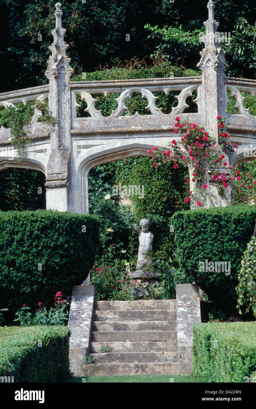 Stone steps up to stone statue below Gothic bridge in large country ...