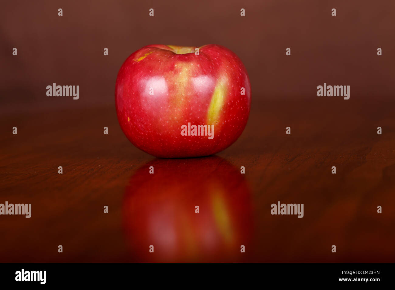 A single macintosh apple on a wood table with slight reflection Stock ...