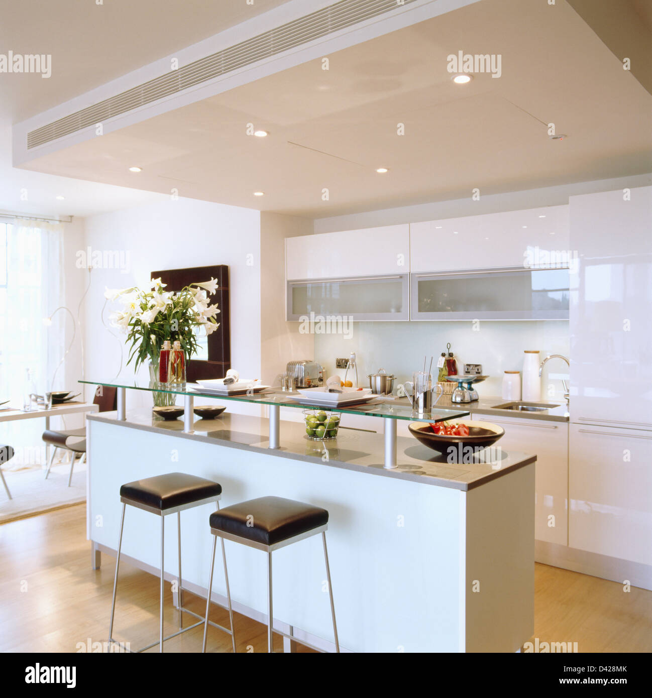 Leather+chrome stools at breakfast bar on island unit in modern white ...