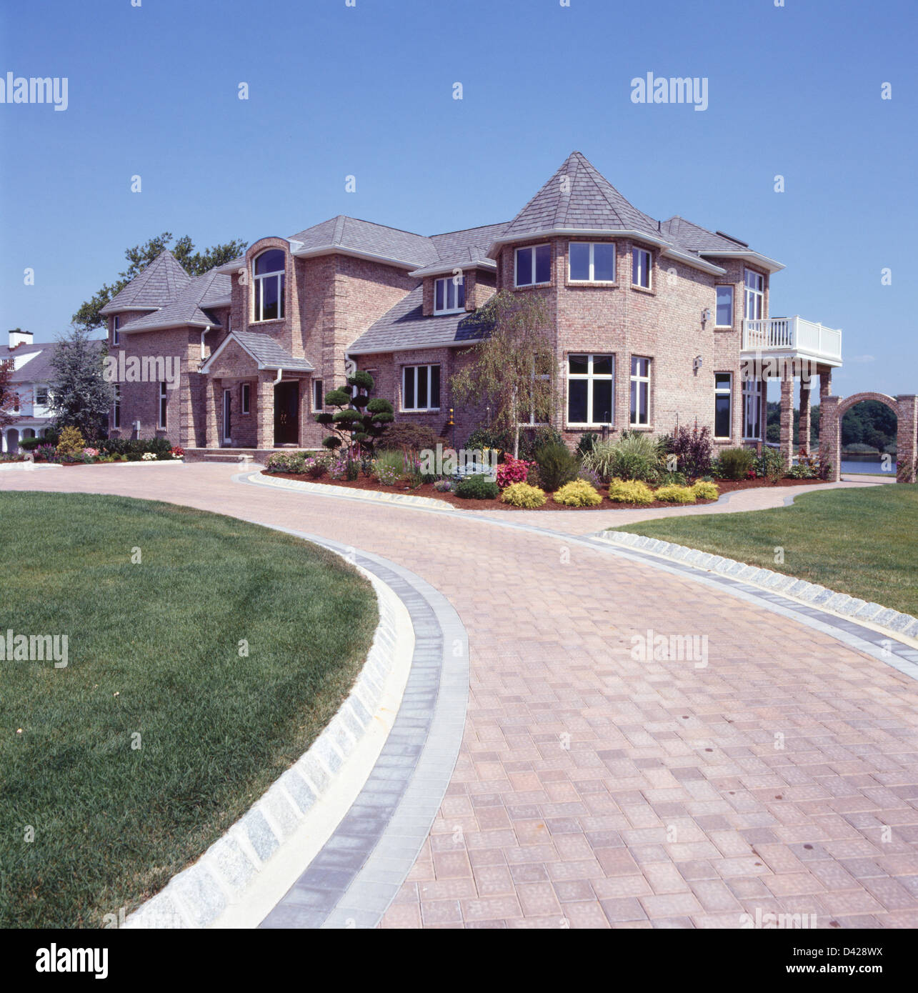 Brick paved drive to large, newly built house in the traditional style ...