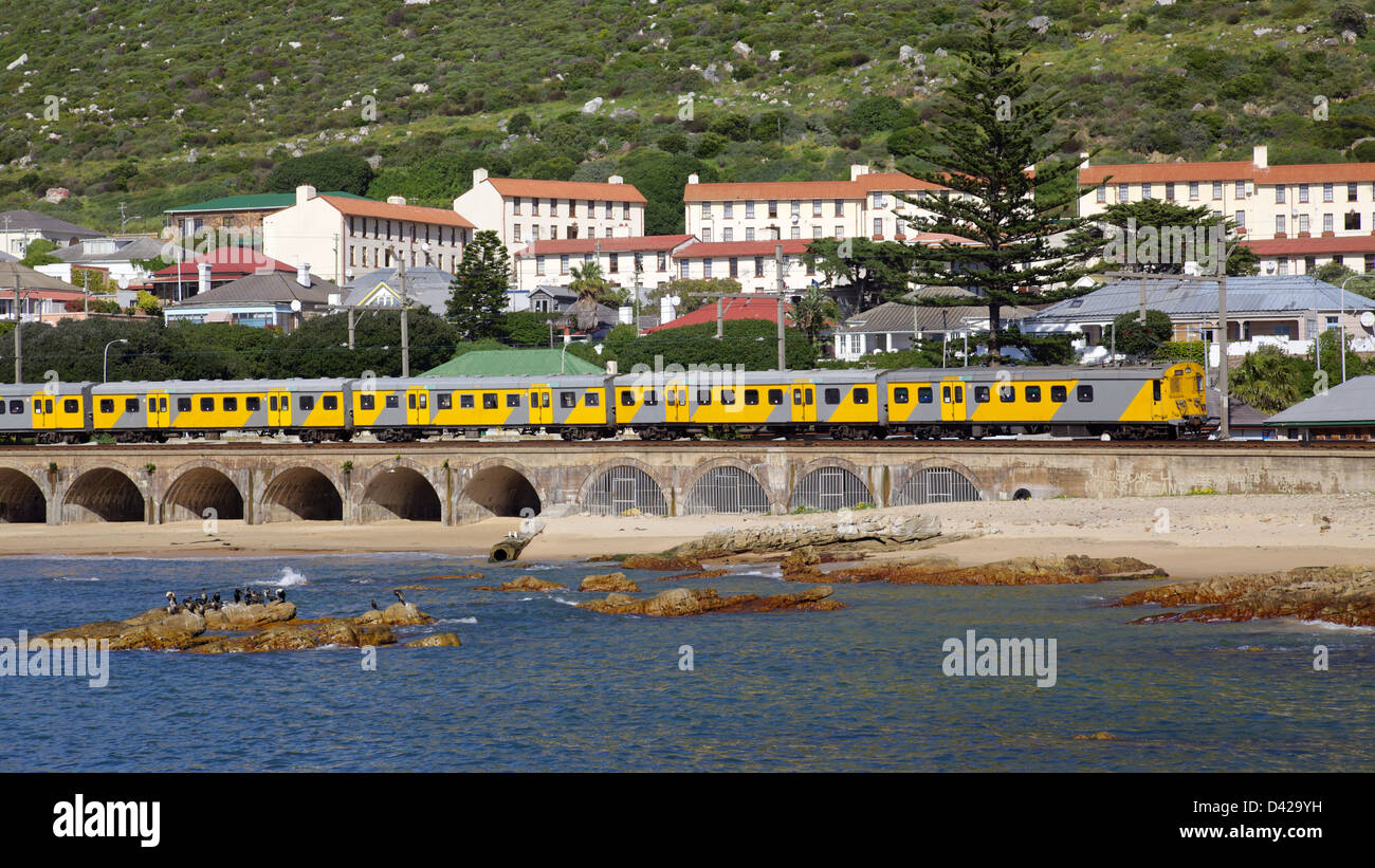 A commuter train passes Kalk Bay Harbour Beach, on the scenic suburban ...