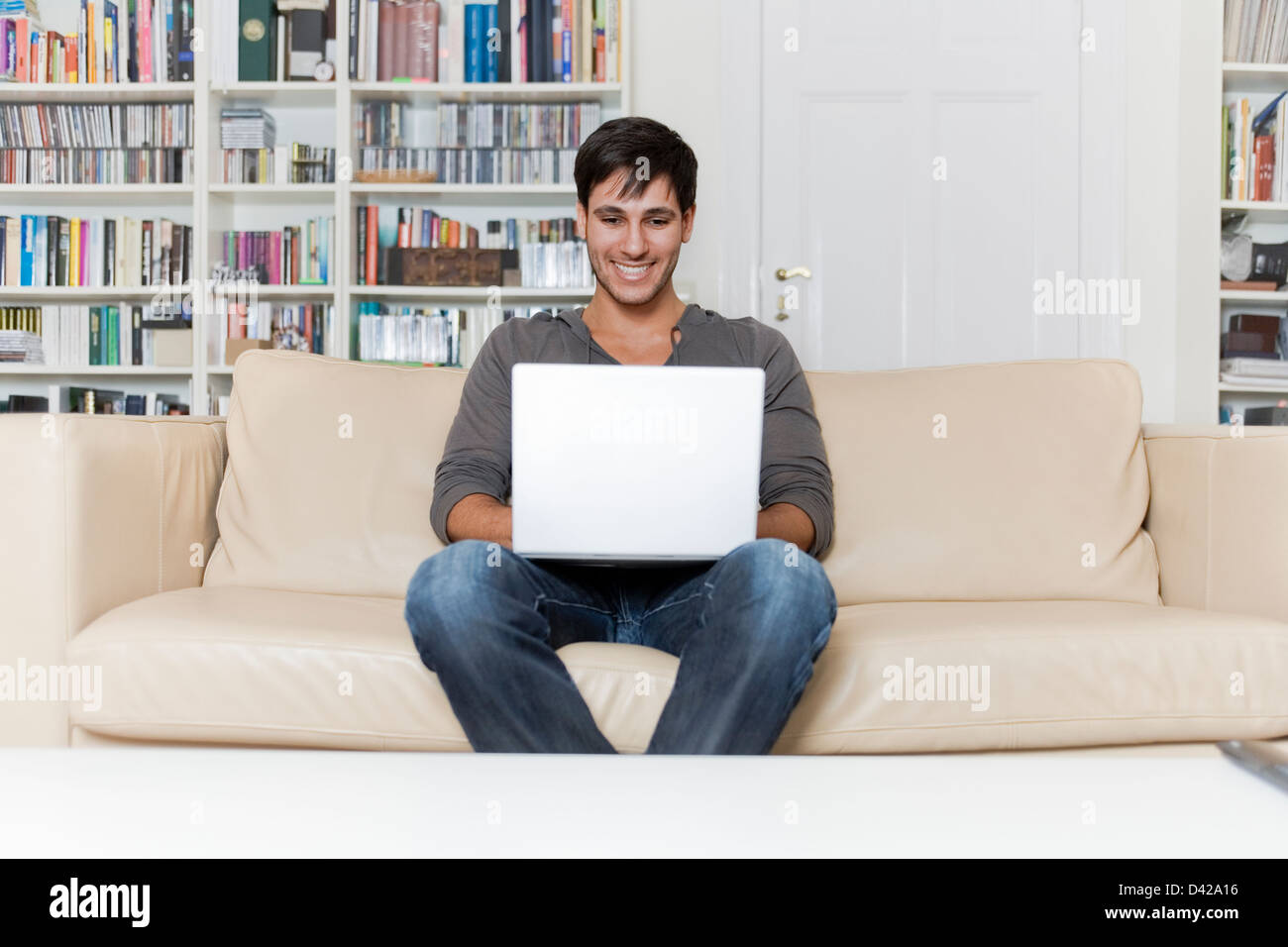 Man comfortable at home using his laptop to surf the internet and do ...