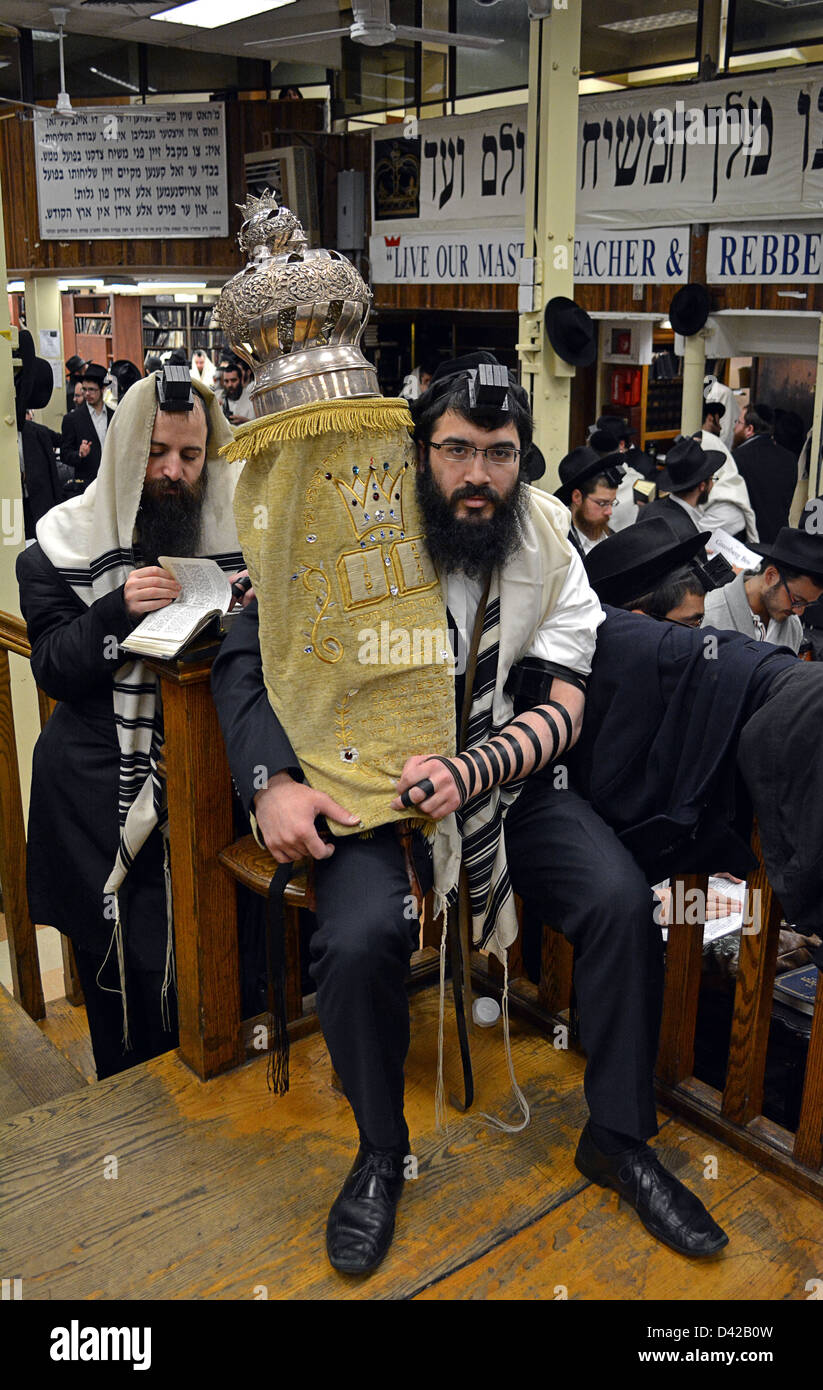 Worshiper holding a Torah during weekday morning prayers at Lubavitch ...