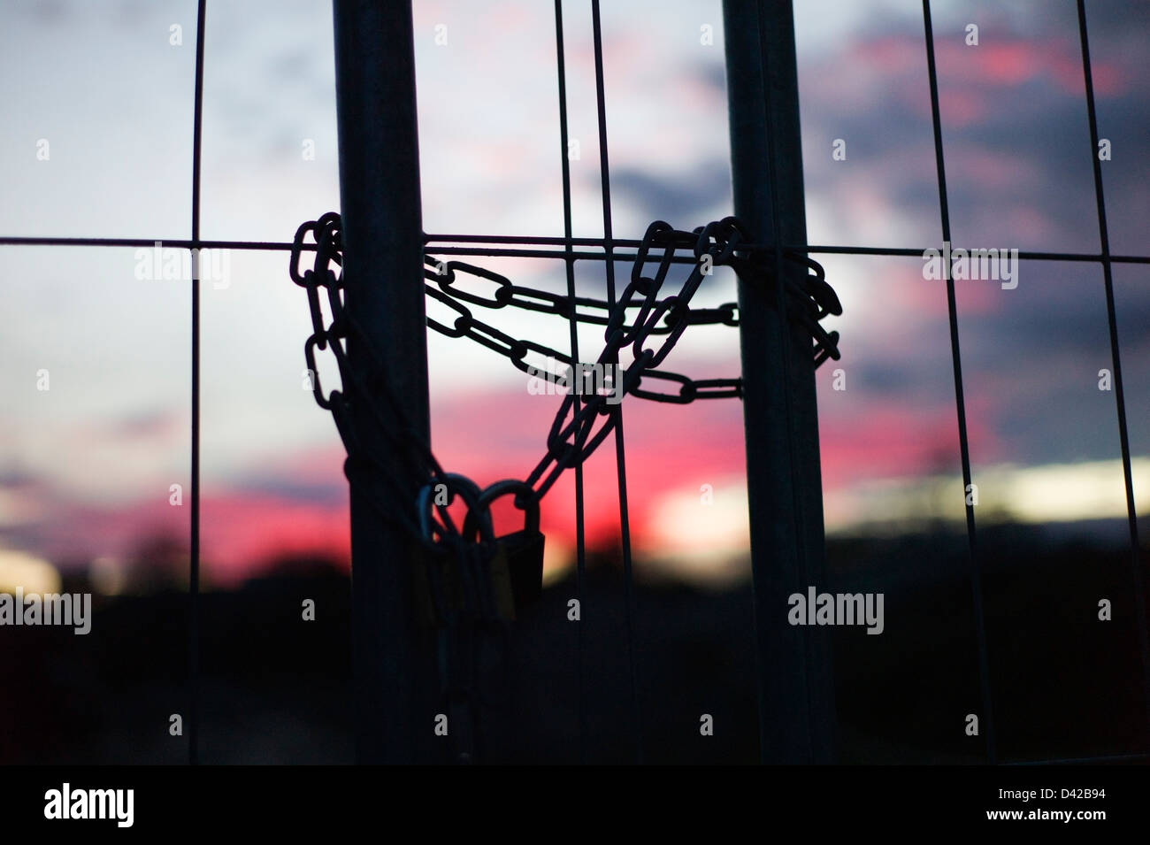 Lock and chain on a building site fence Stock Photo - Alamy