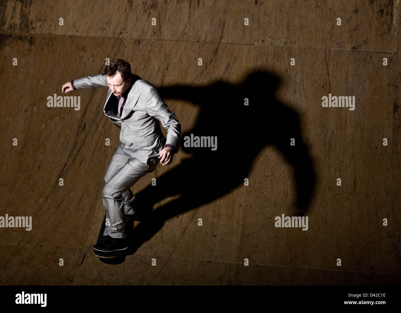 Man in suit on skateboard ramp with shadow Stock Photo - Alamy