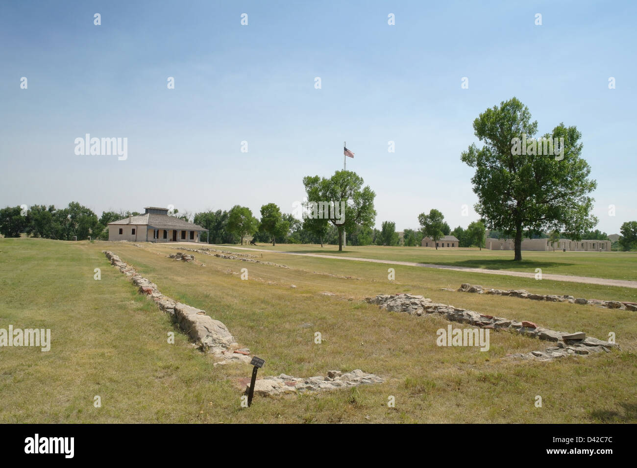Blue sky view old barracks ruins extending green grass to New ...