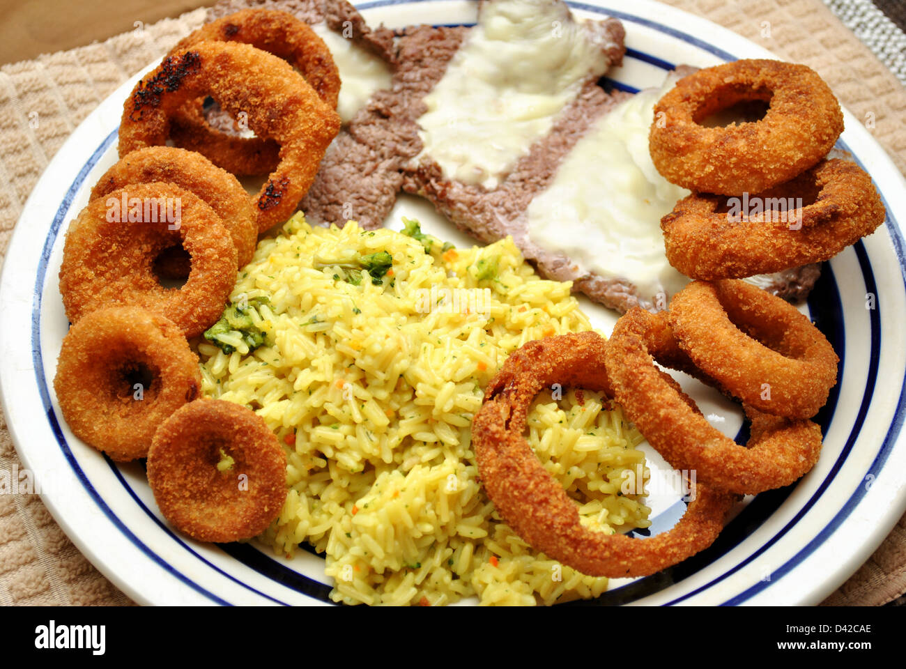 Meal with Meat, Rice and Onion Rings Stock Photo - Alamy