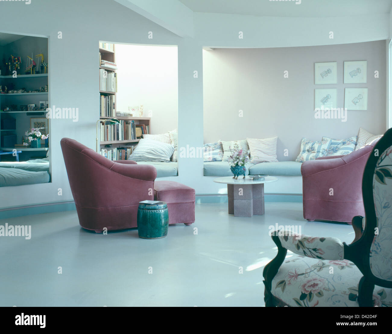 Pink velvet armchairs and built in seating in modern open-plan living ...