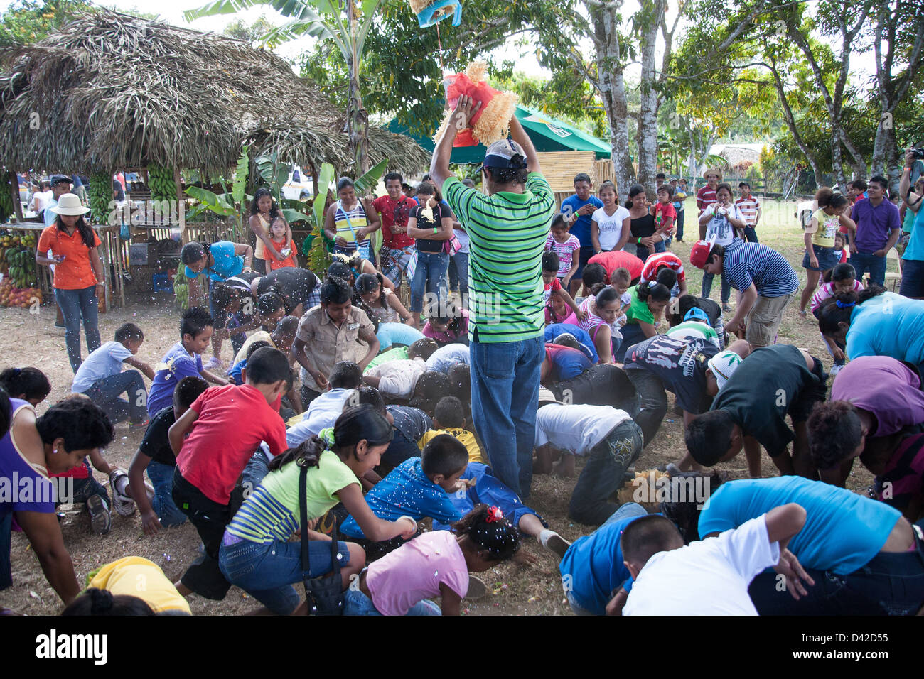 A broken open pinata and a guy showering the contents such as candy and ...