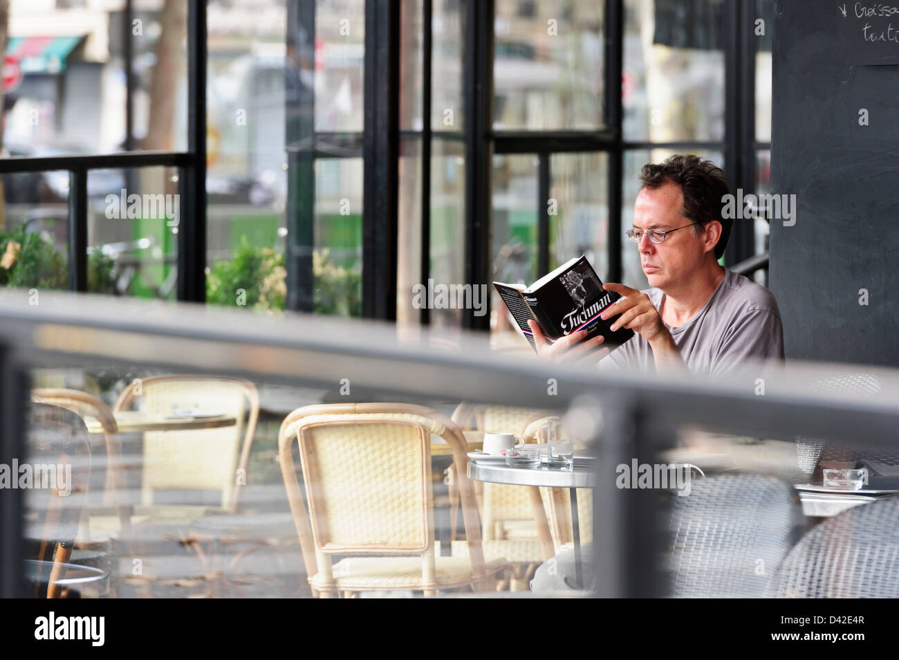 Man reading a book in a French Restaurant, Paris, France Stock Photo ...