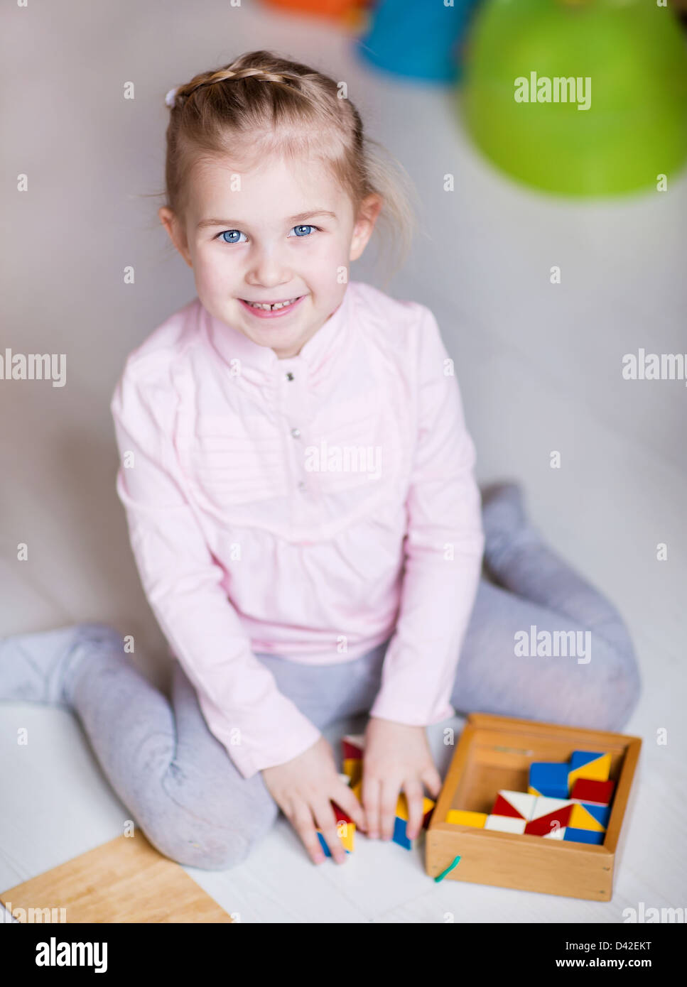 Cute little girl playing with blocks on the floor Stock Photo - Alamy