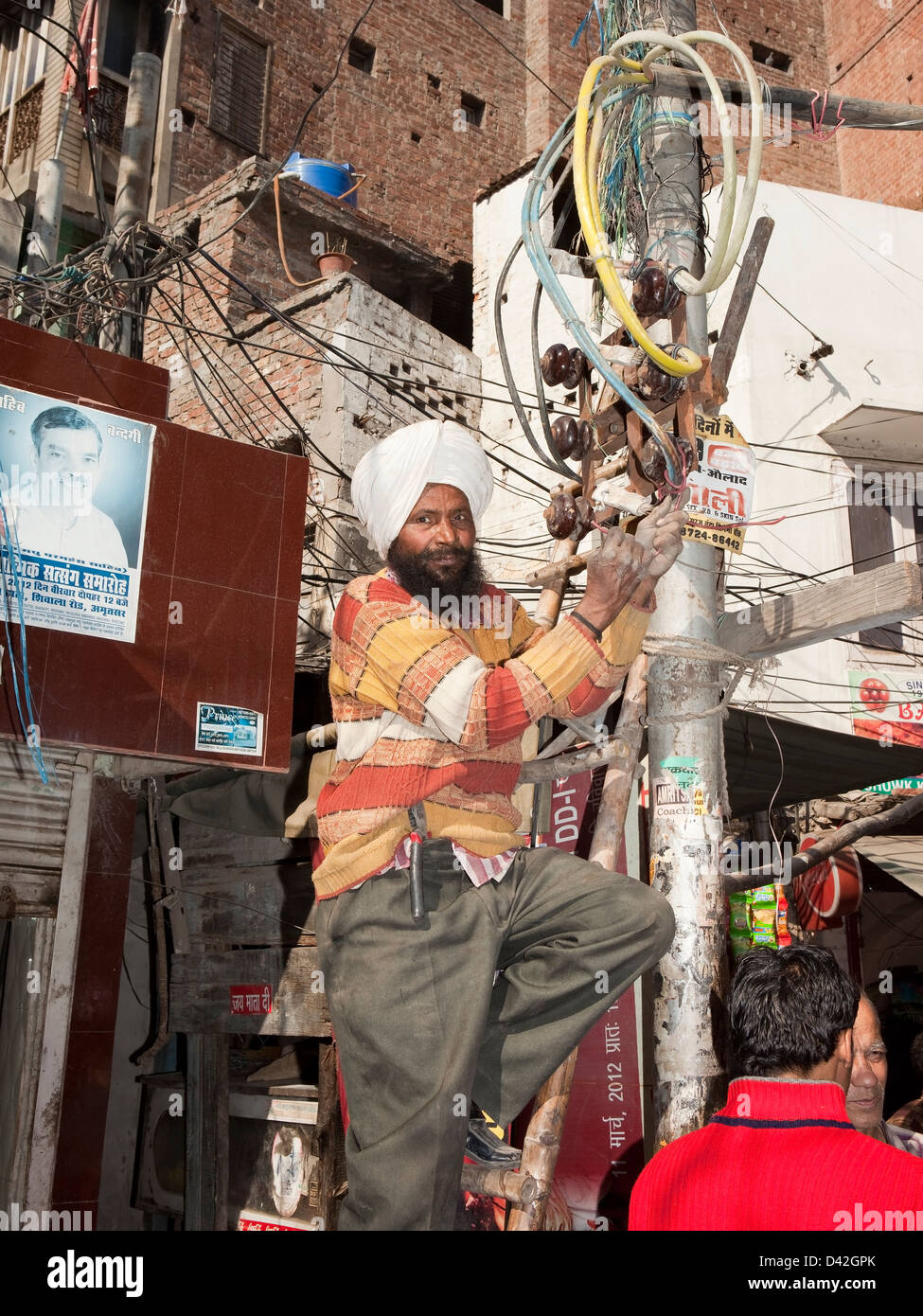 A Sikh electrician fixing wires in the Holy city of Amritsar in Punjab ...