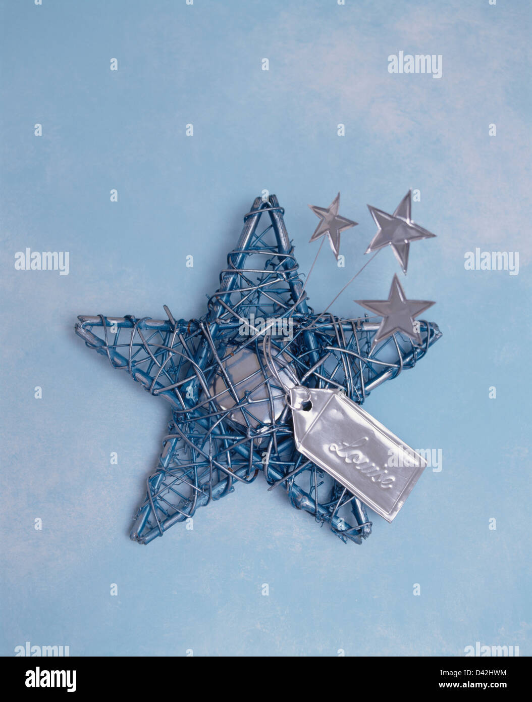 Painted blue twig star gift tag with punched tin name Stock Photo - Alamy