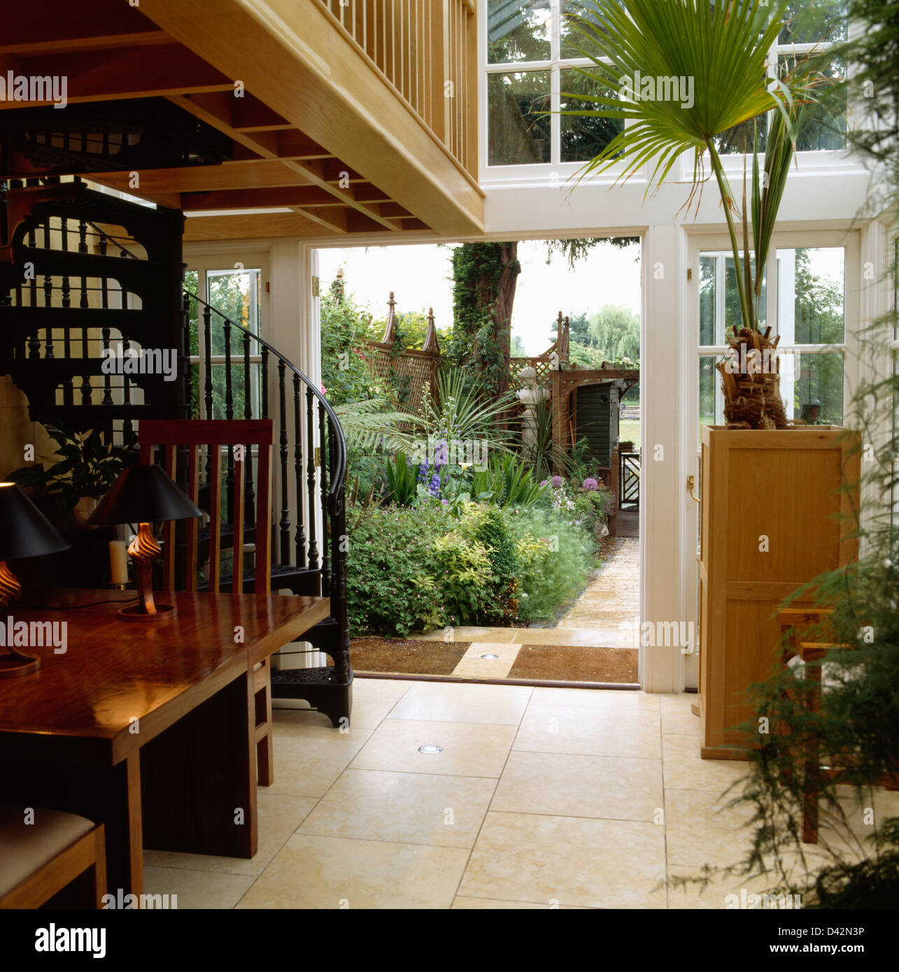 Travertine tiled floor in large conservatory dining room with tall palm ...