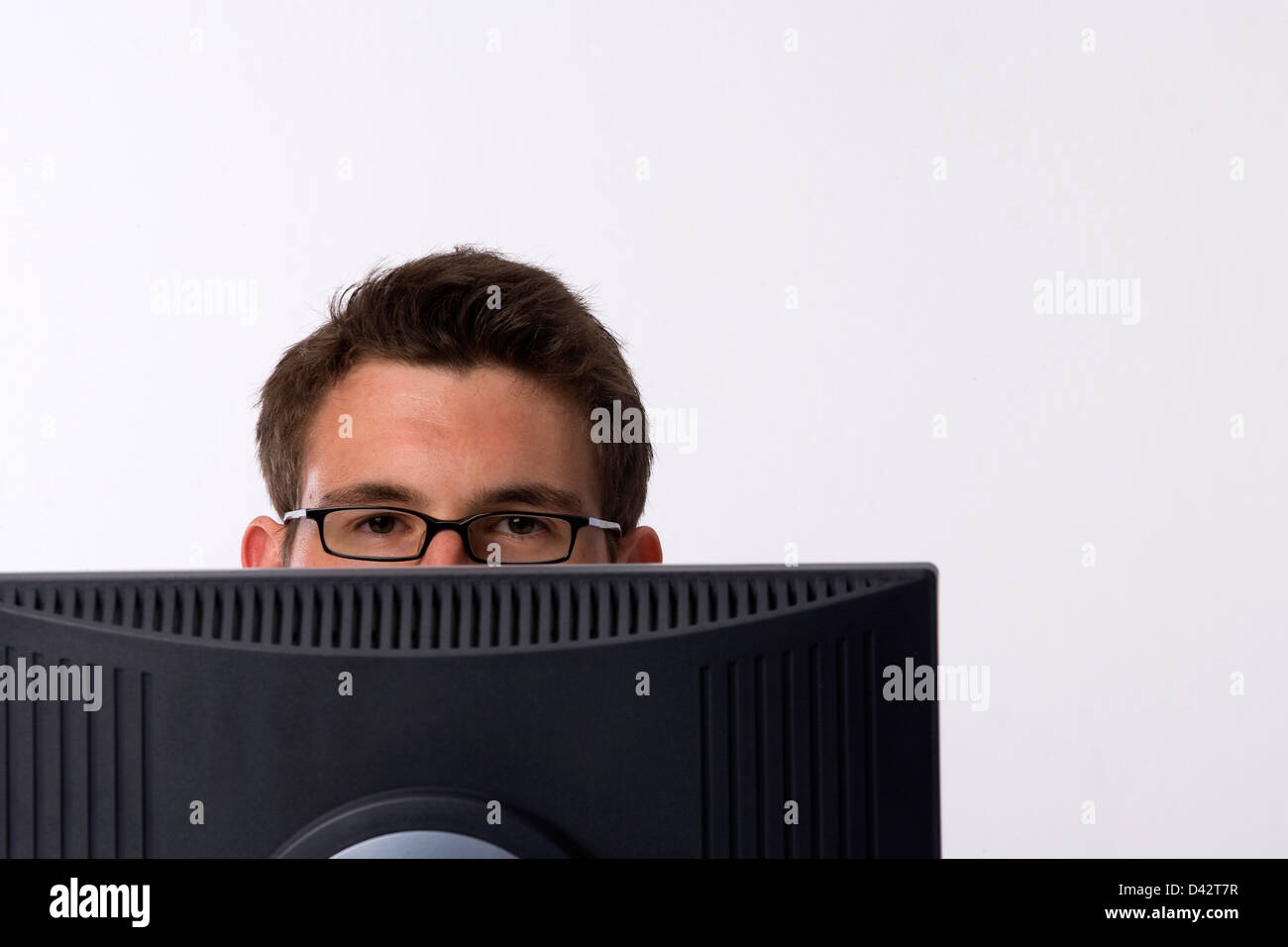 Freiburg, Germany, bespectacled man sitting behind a computer monitor ...