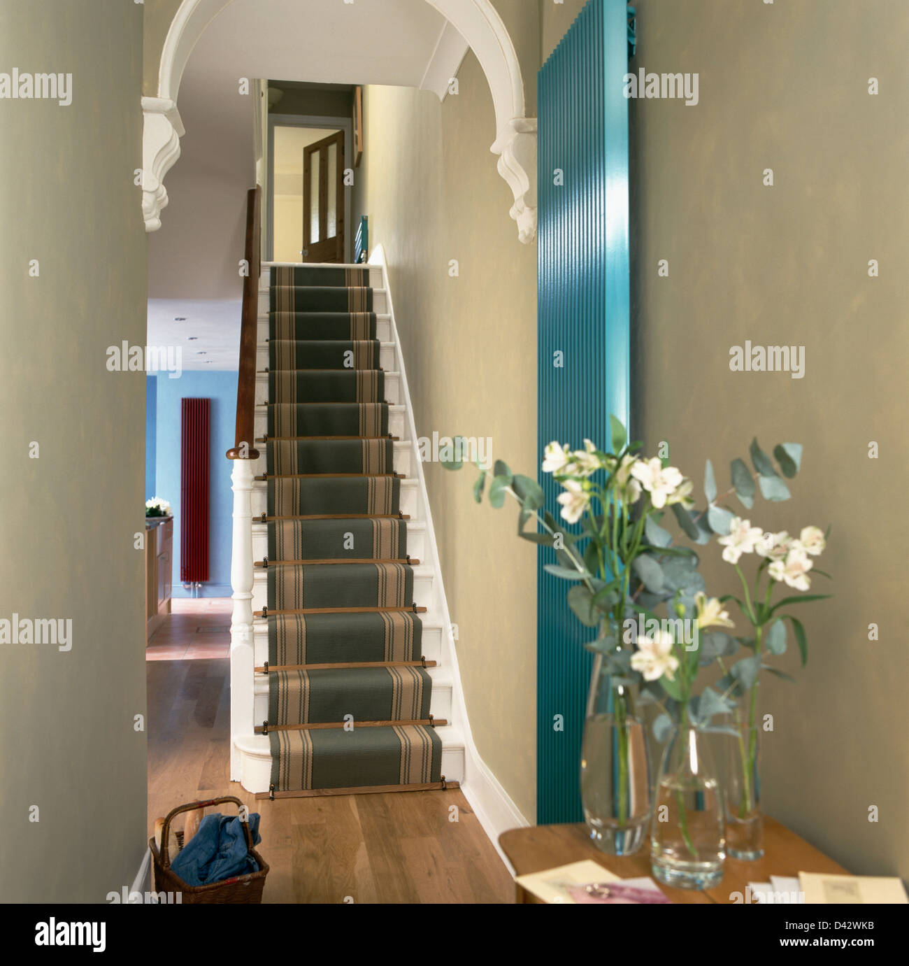 Vertical turquoise radiator on wall in gray traditional hall with ...