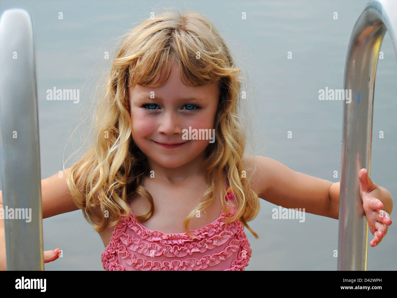 A young girl on a ladder ready to enjoy a swim Stock Photo - Alamy