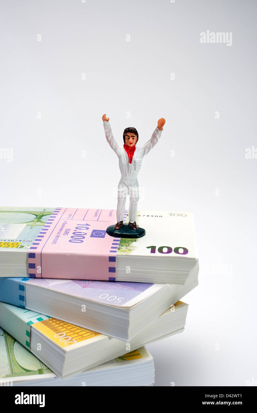 Freiburg, Germany, figure with raised arms standing on a stack of euro ...