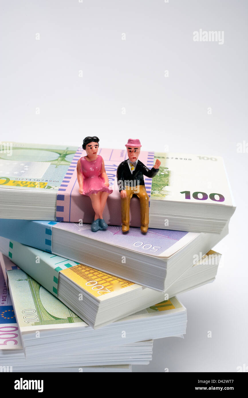 Freiburg, Germany, retiree figures sitting on a stack of euro notes ...