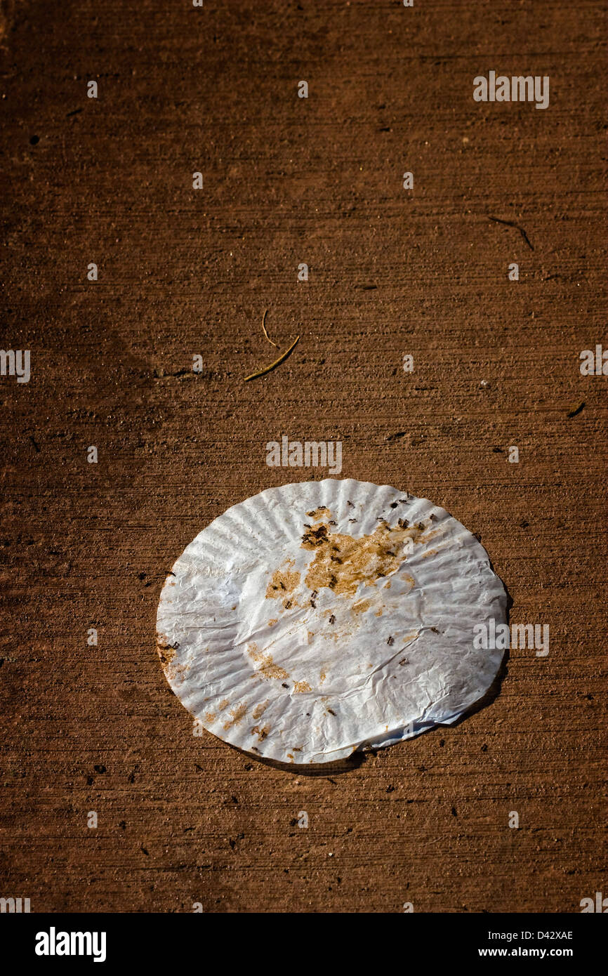 A discarded cupcake liner with ants swarming for the crumbs Stock Photo ...
