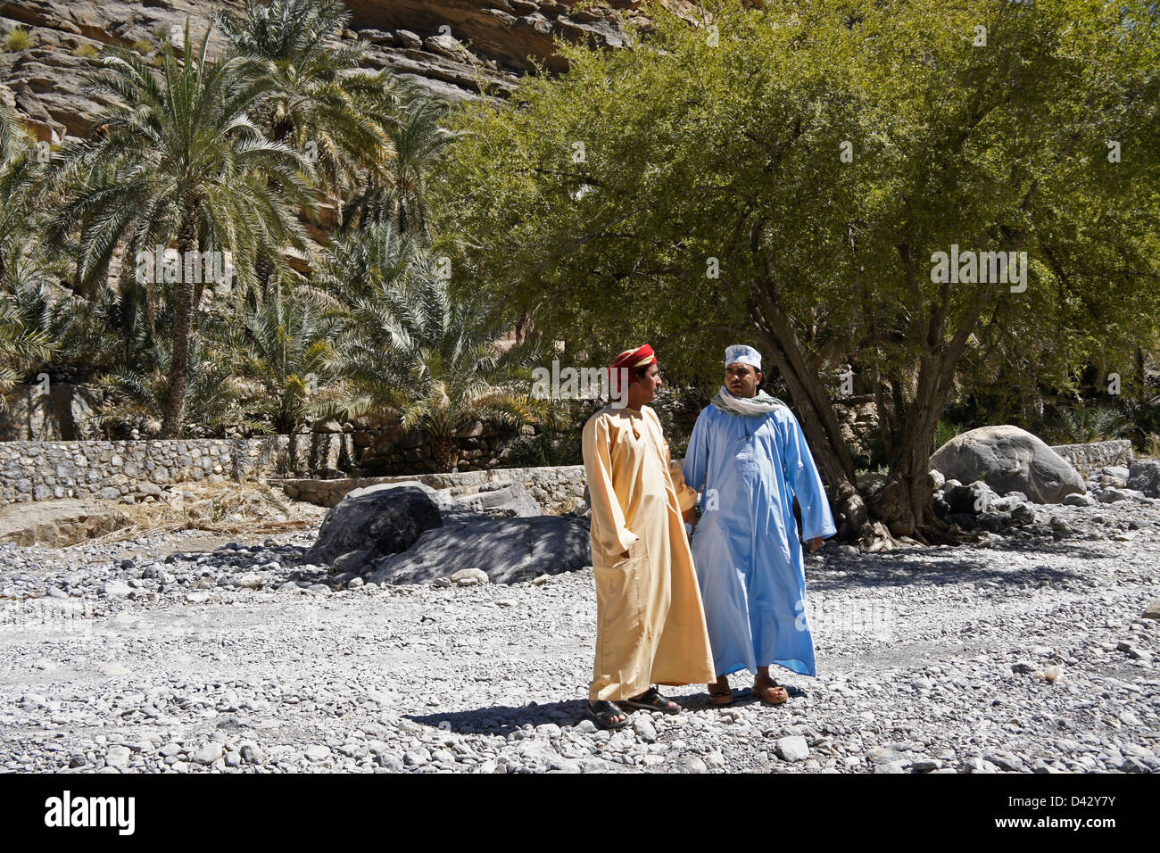 Omani men in traditional dress walking in Wadi Ghul, near Nizwa, Oman ...