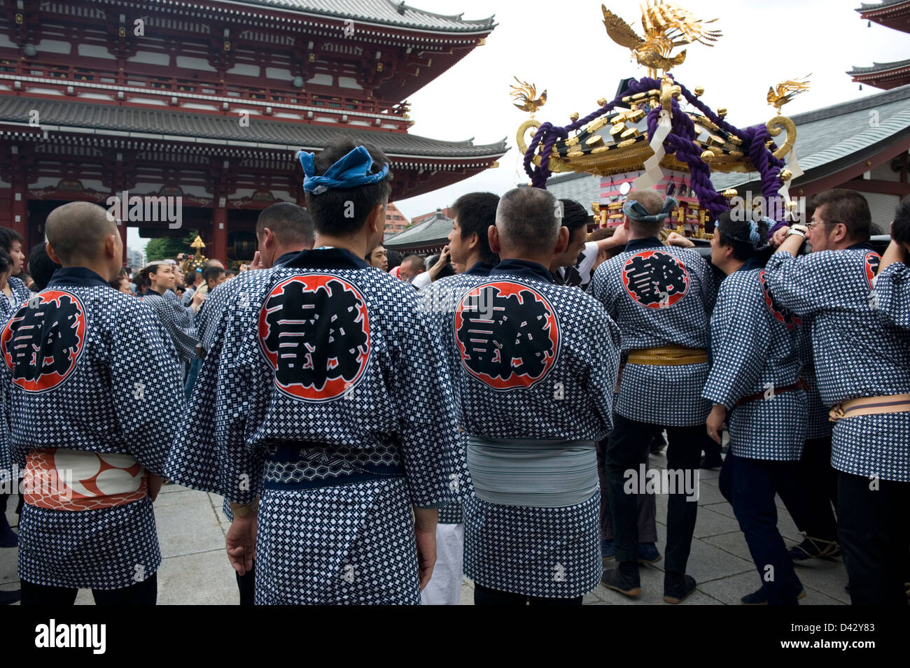 Men and women carry a gold decorated sacred mikoshi portable shrine in ...