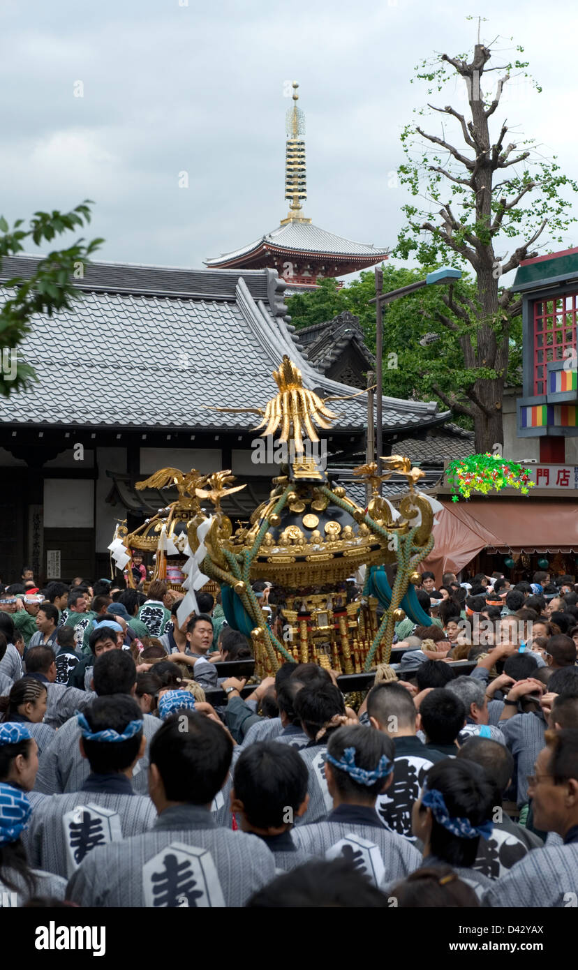 Men and women carry a gold decorated sacred mikoshi portable shrine in ...