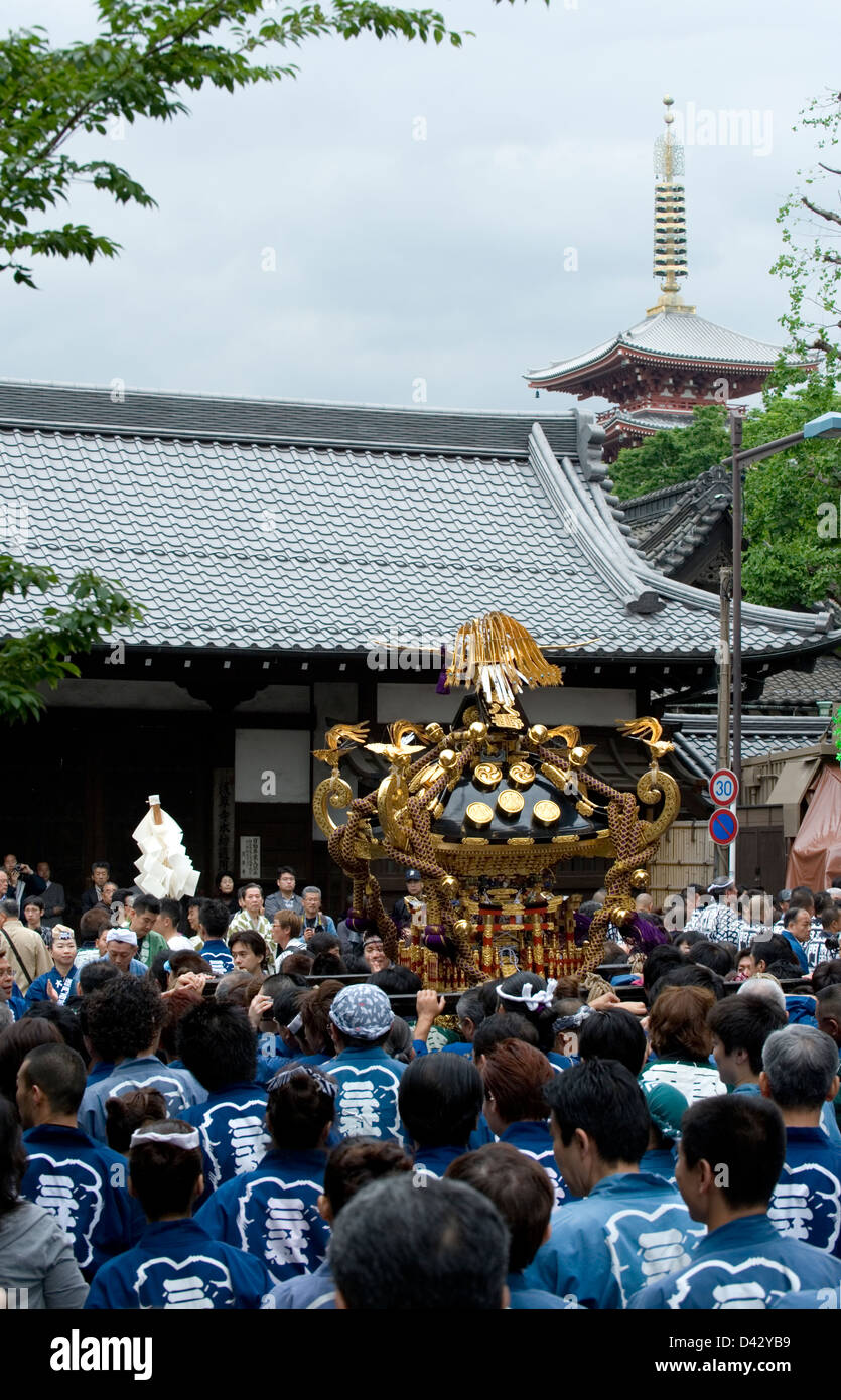 Men and women carry a gold decorated sacred mikoshi portable shrine in ...