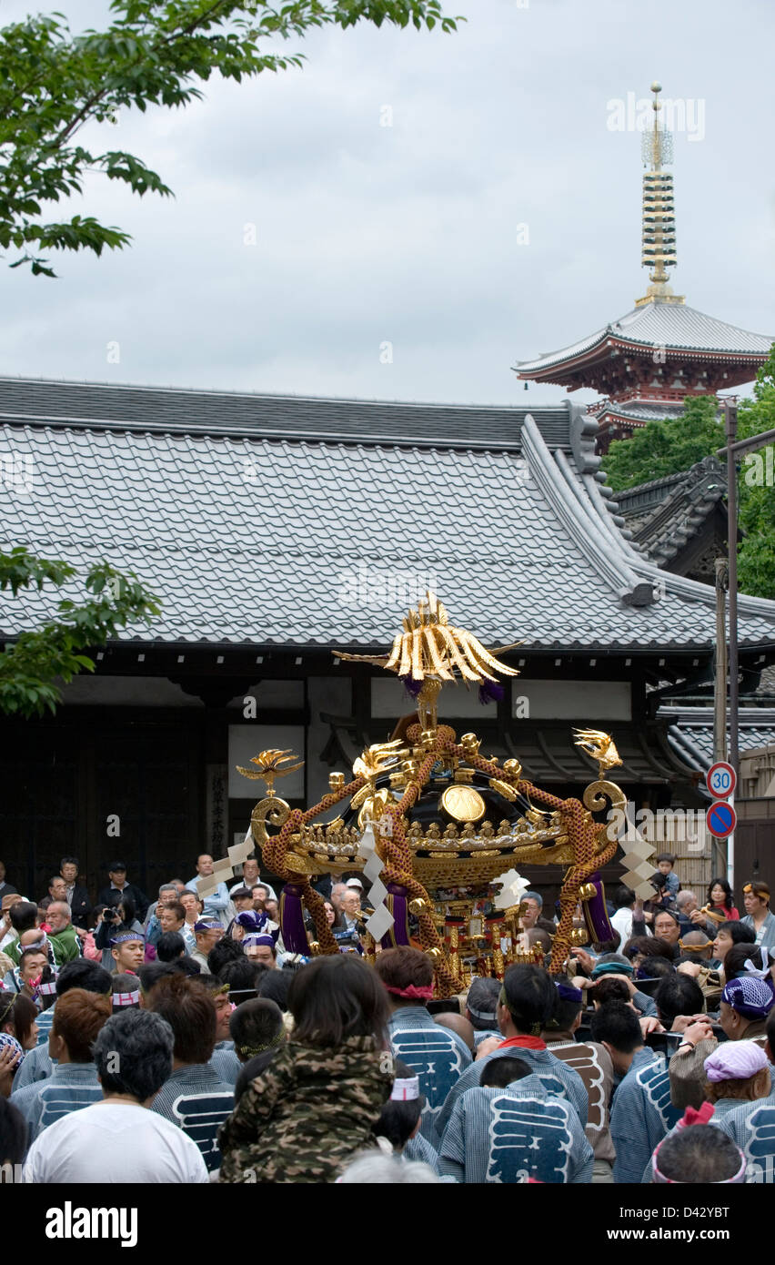 Men and women carry a gold decorated sacred mikoshi portable shrine in ...